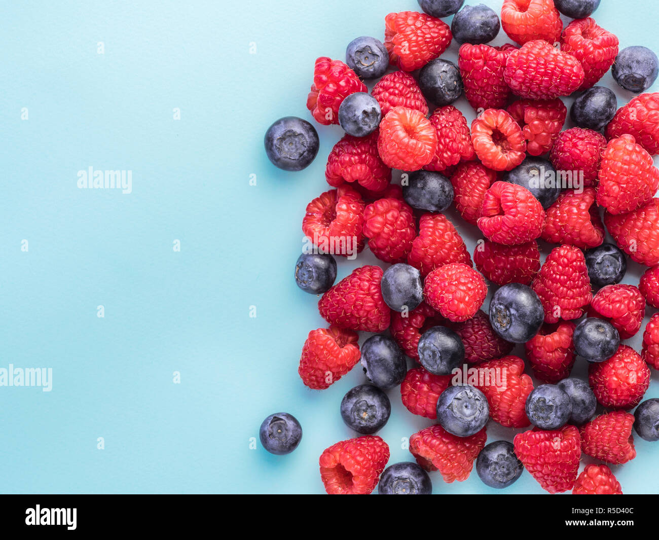 Raspberry and blueberry on blue background with copy space Stock Photo ...