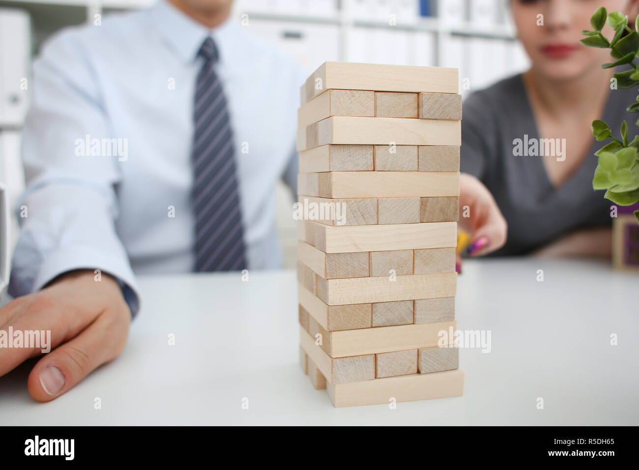 Businessman plays in a strategy of jenga hand Stock Photo - Alamy