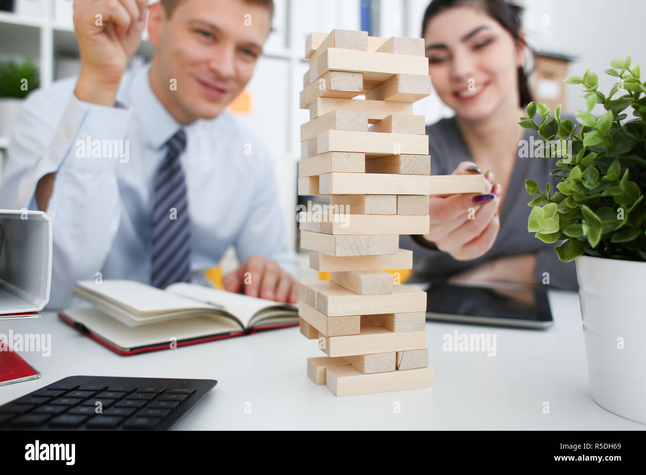 Businessman plays in a strategy of jenga hand Stock Photo - Alamy