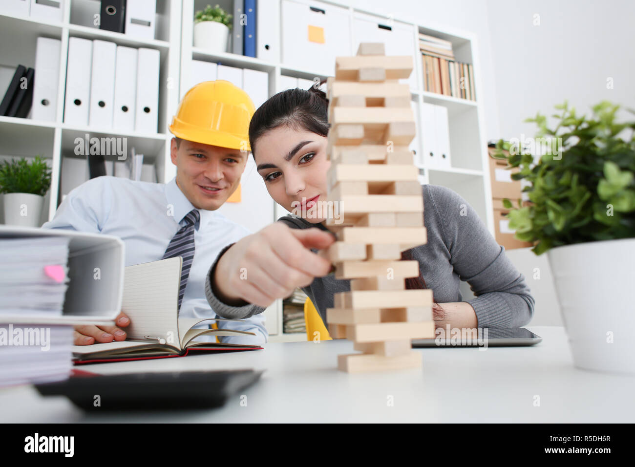 Businessman plays in a strategy of jenga hand Stock Photo - Alamy