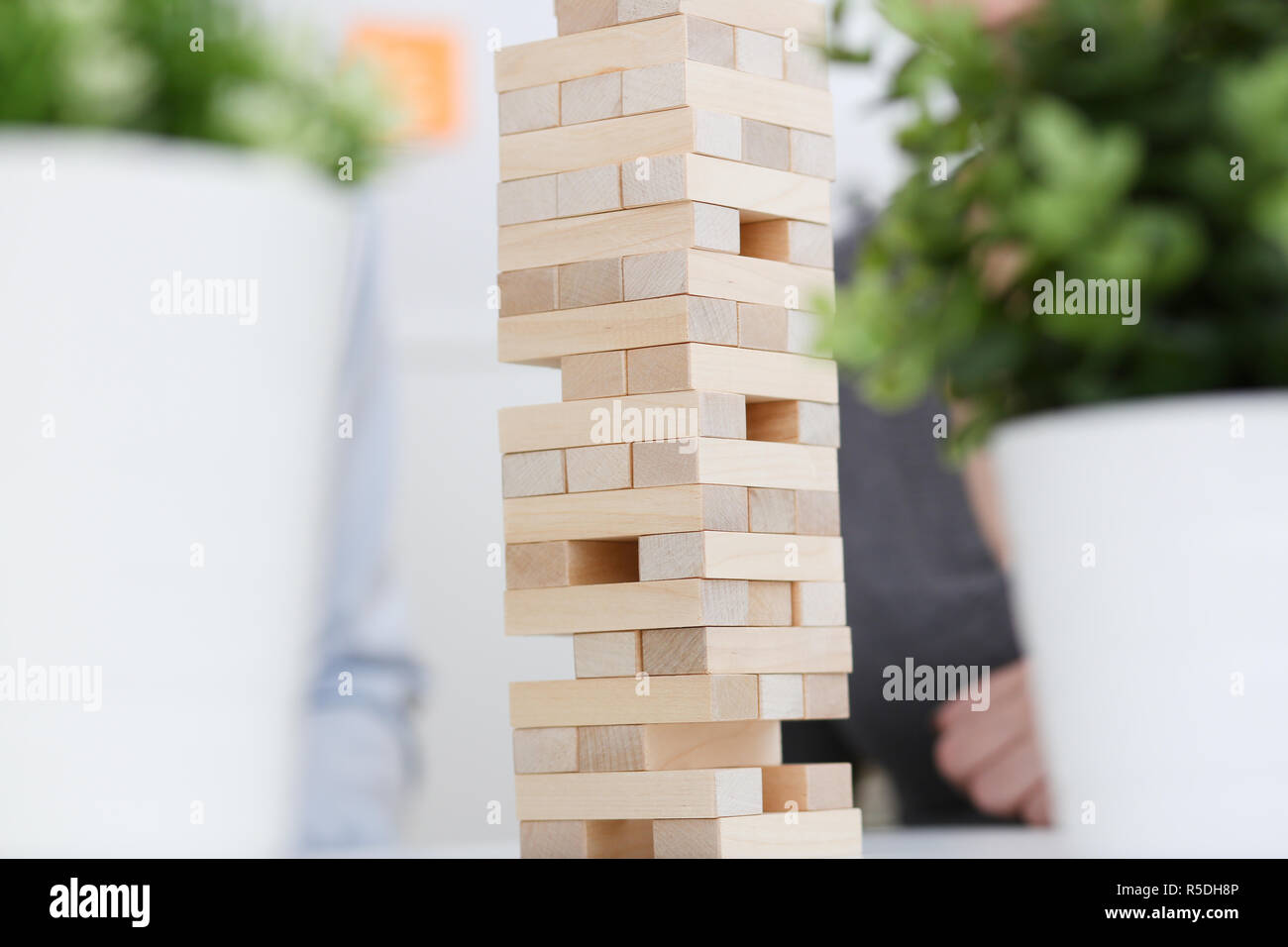 Businessman plays in a strategy of jenga hand Stock Photo - Alamy