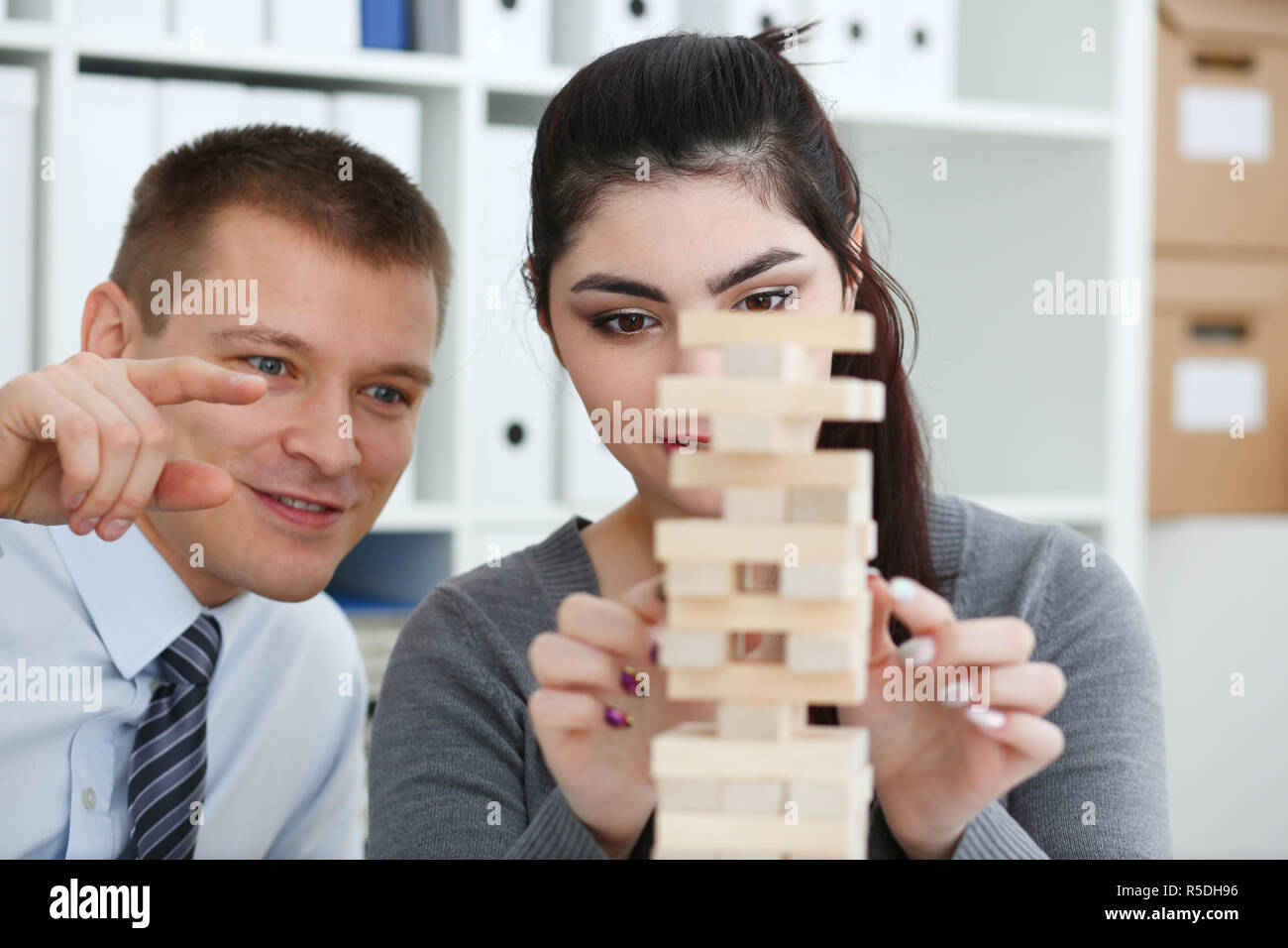 Businessman plays in a strategy of jenga hand Stock Photo - Alamy