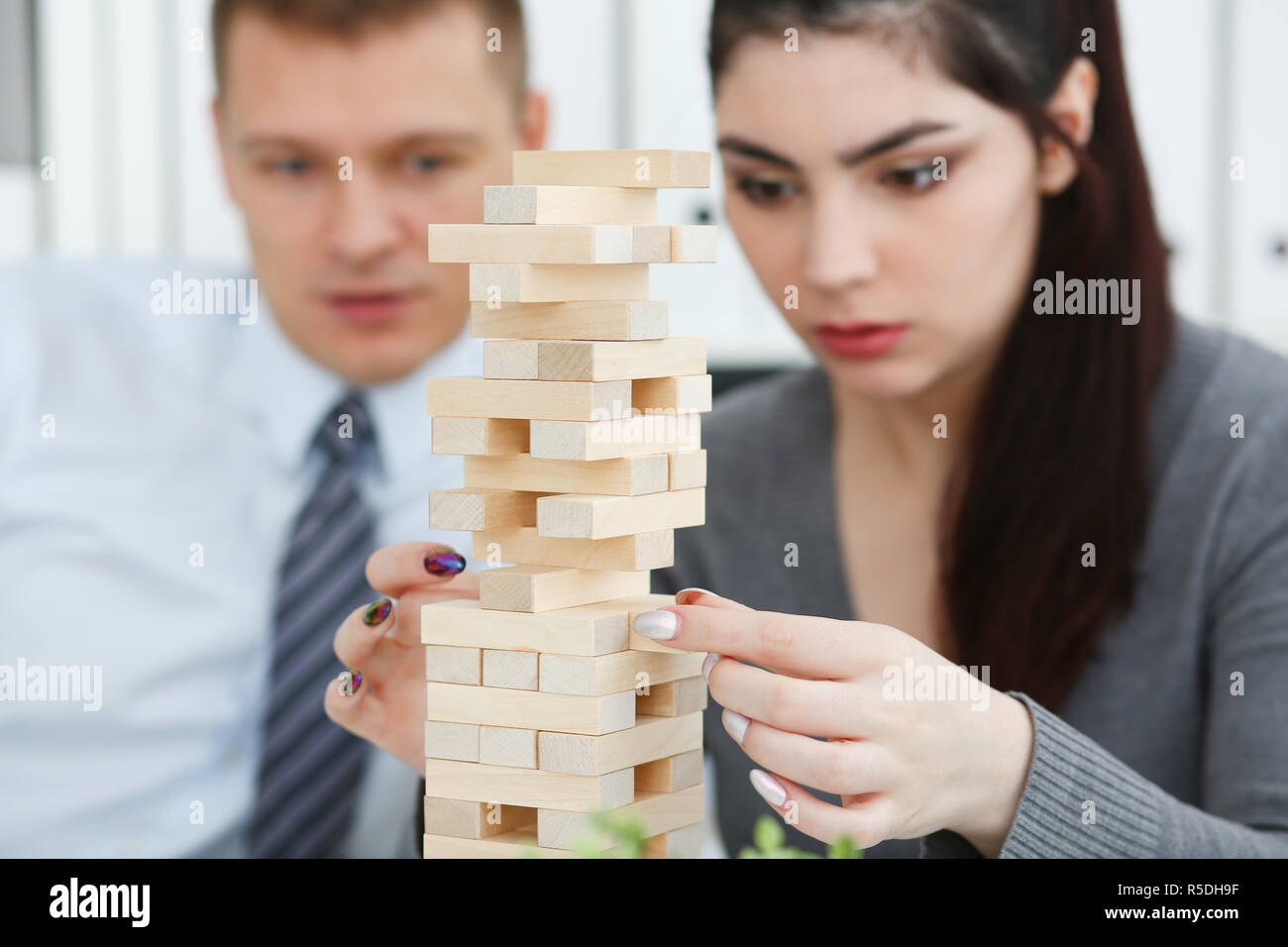 Businessman plays in a strategy of jenga hand Stock Photo - Alamy