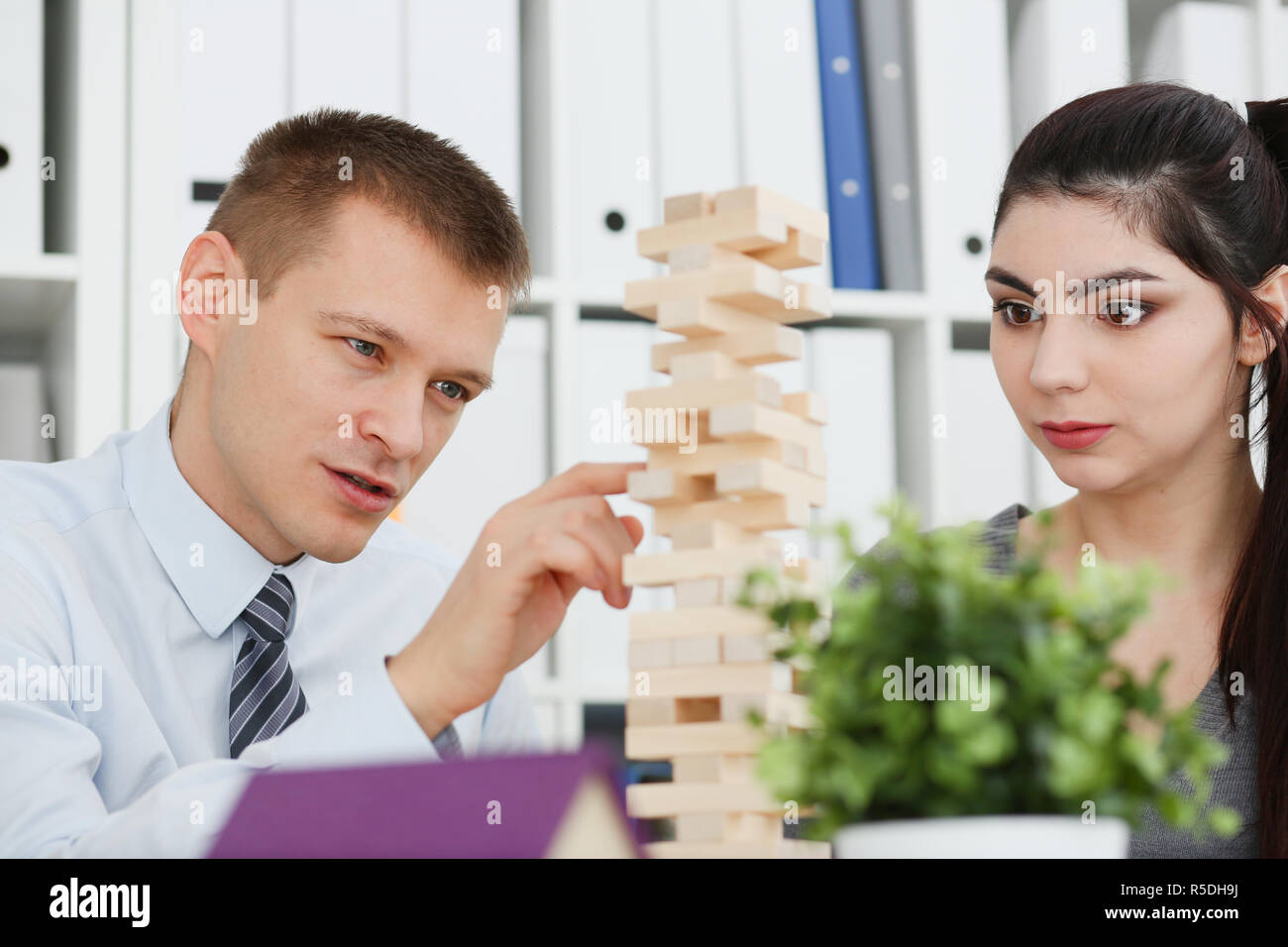 Businessman plays in a strategy of jenga hand Stock Photo - Alamy