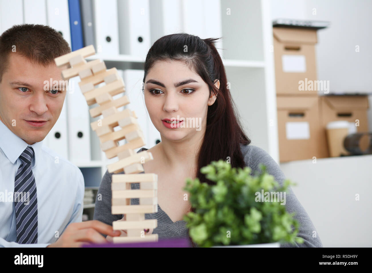 Businessman plays in a strategy of jenga hand Stock Photo - Alamy