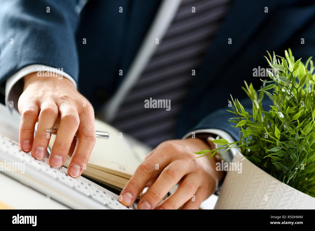 Male arms in suit typing on silver keyboard Stock Photo - Alamy