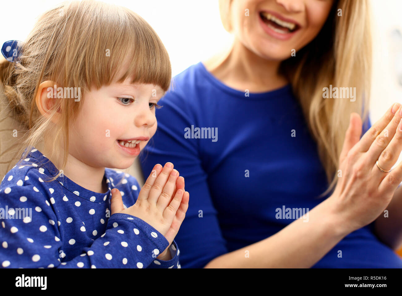 Cute little girl play with mom pat-a-cake Stock Photo - Alamy
