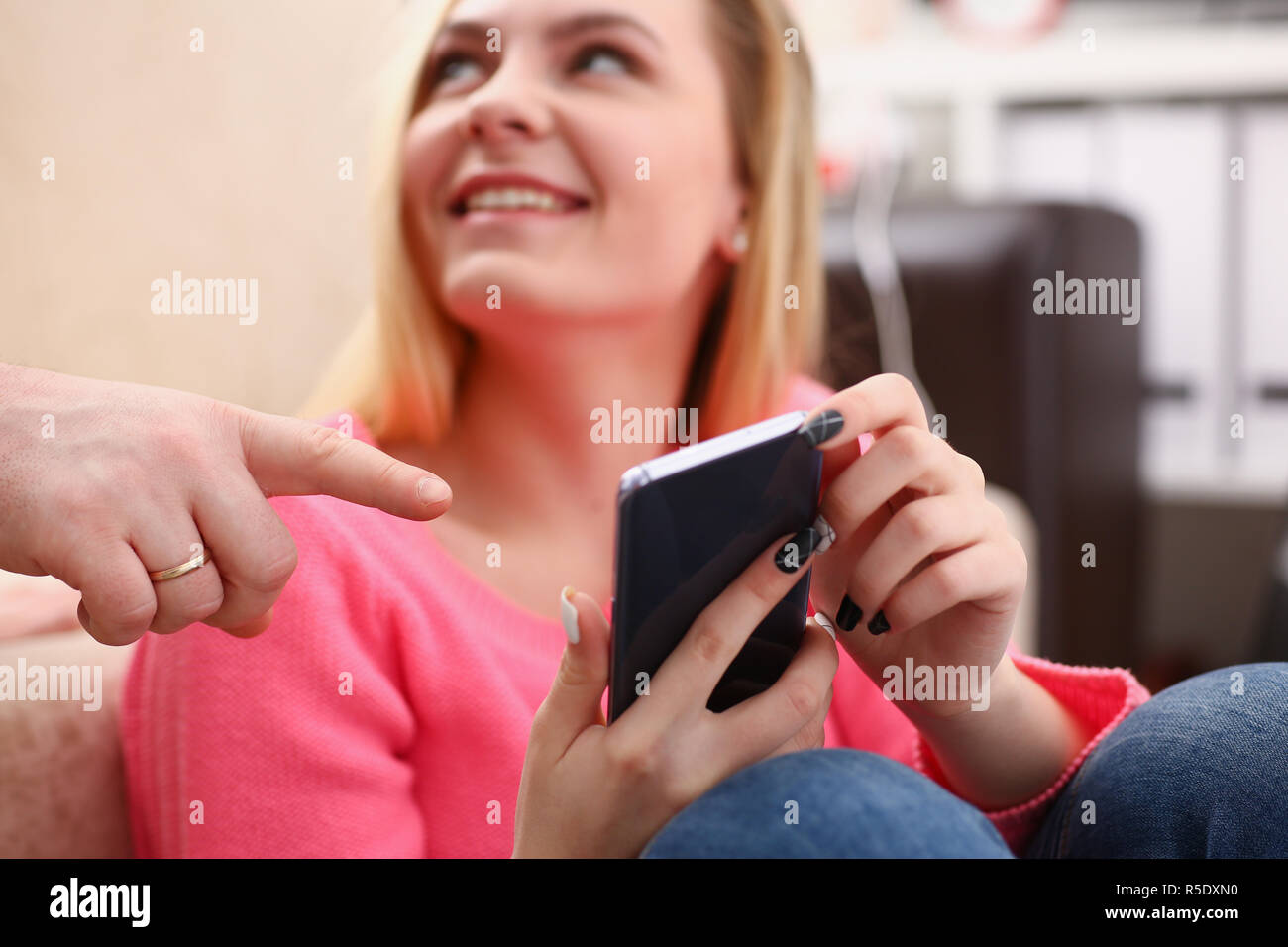 young pretty blond womansit on sofa hold smartphone in hands Stock ...