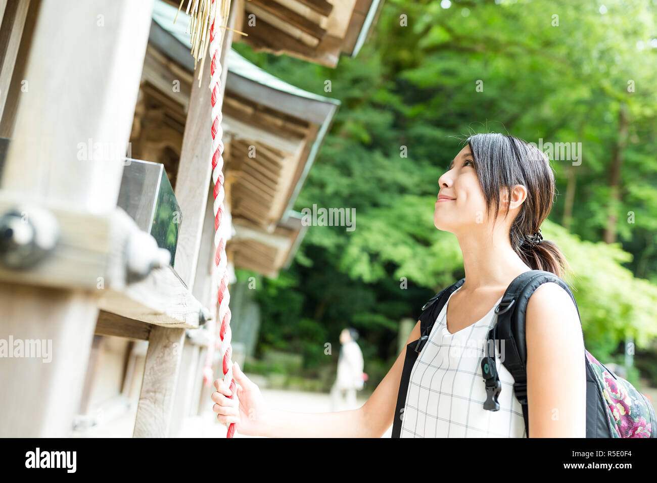 Woman ringing the bell in Japanese temple Stock Photo - Alamy
