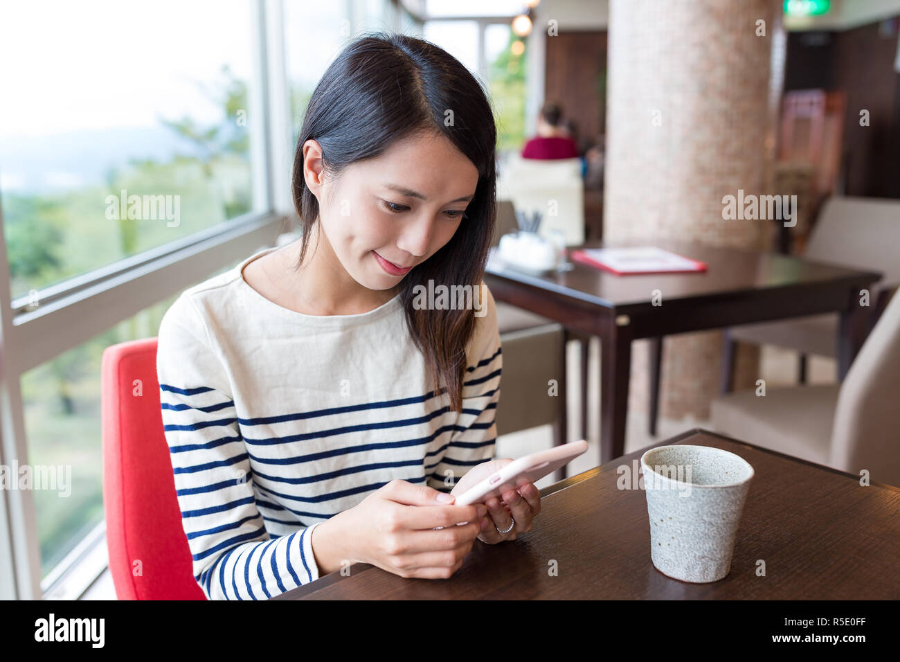 Woman use of mobile phone in coffee shop Stock Photo - Alamy