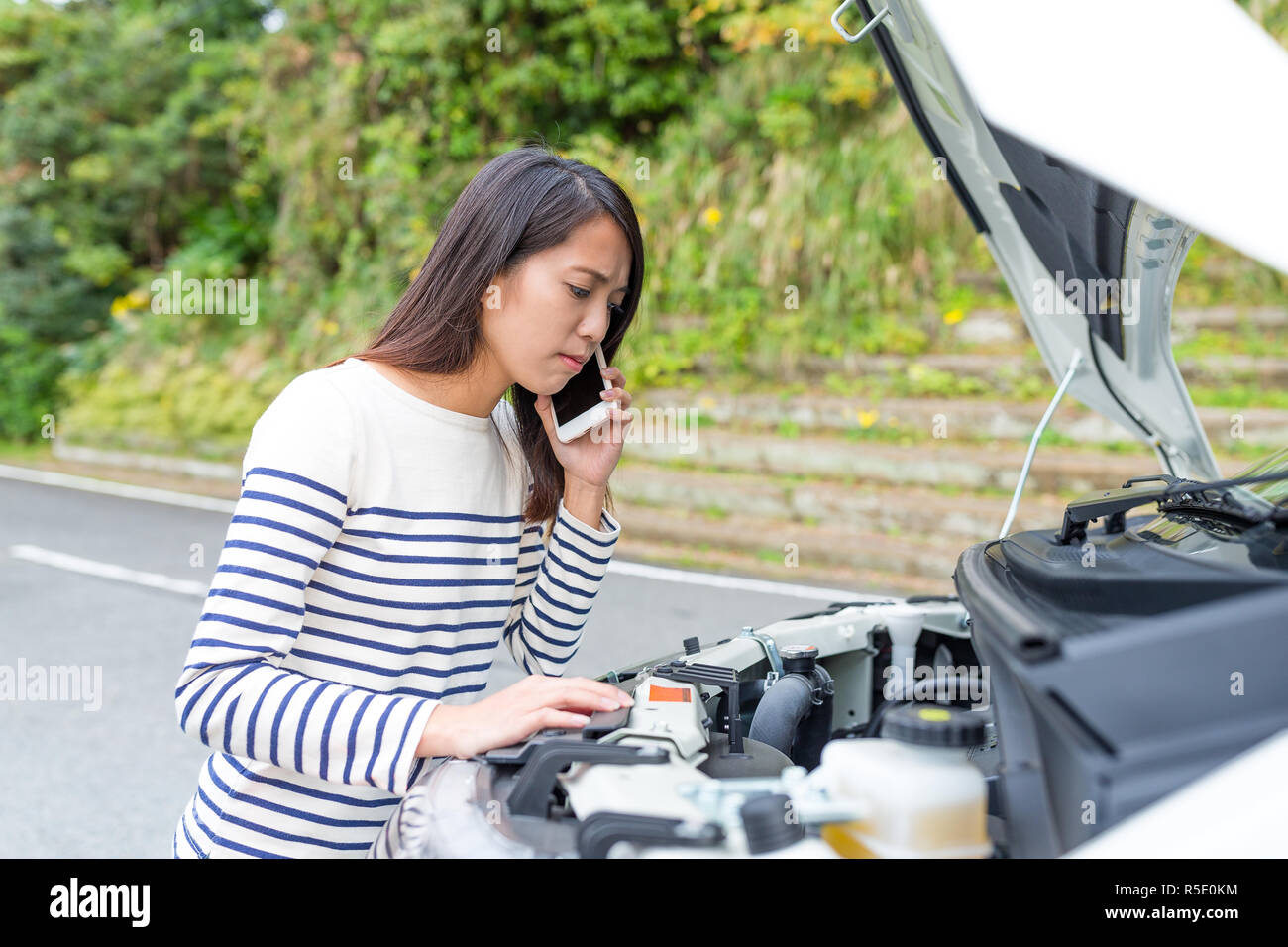 Woman calling for help with car broken in roadside Stock Photo - Alamy