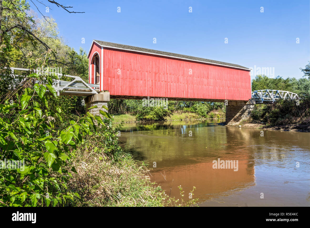 The red Wolf Covered Bridge, with pony truss approaches, crosses the ...