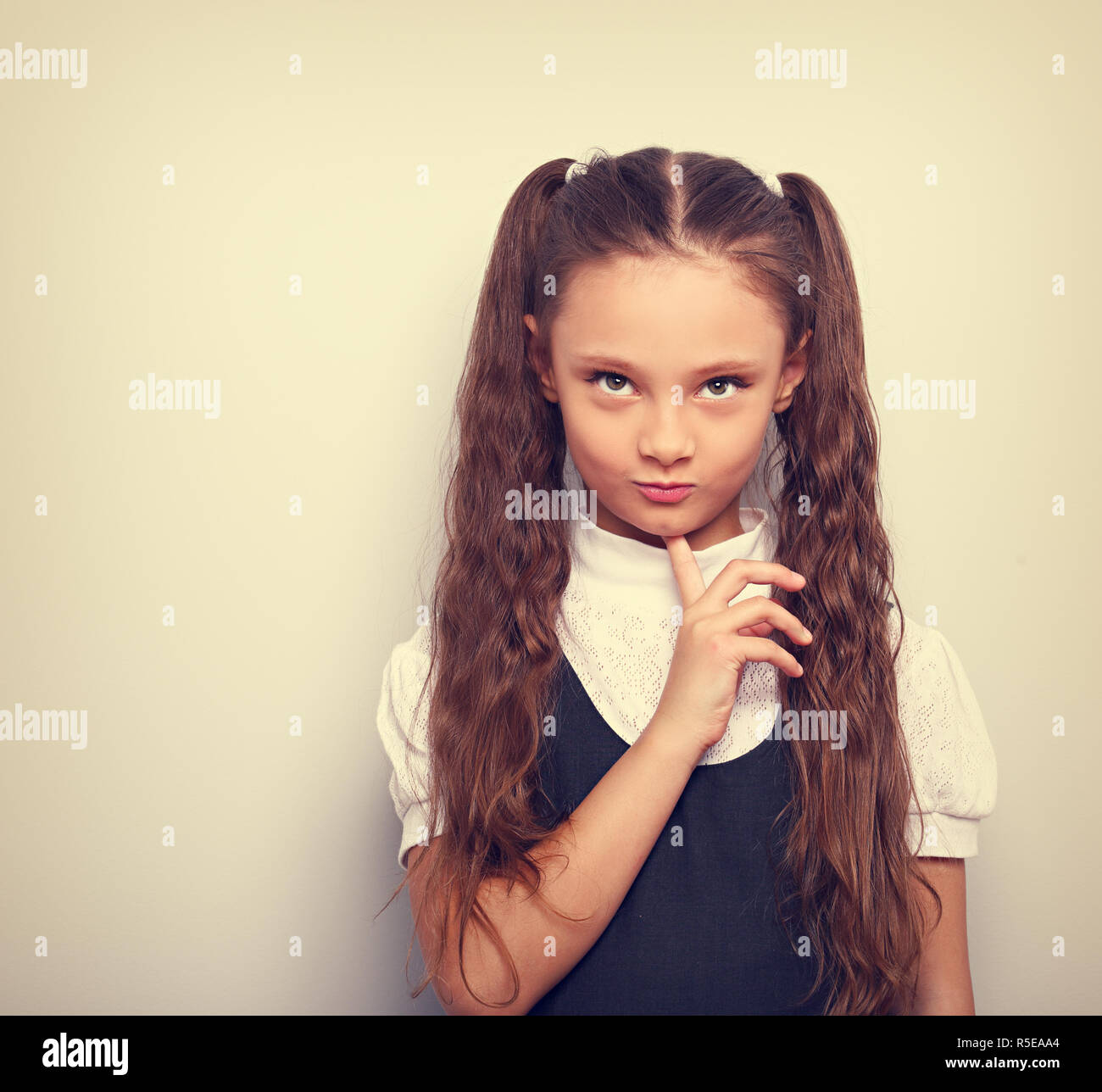 Fun pupil girl school uniform thinking and looking up on blue ...