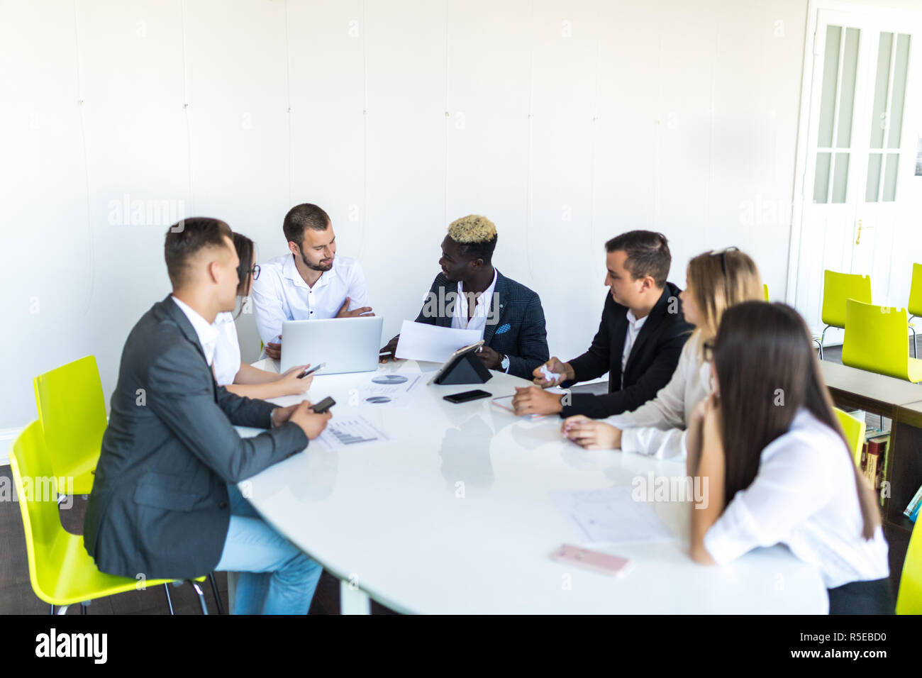 Group of diverse business executives holding a meeting around a table ...