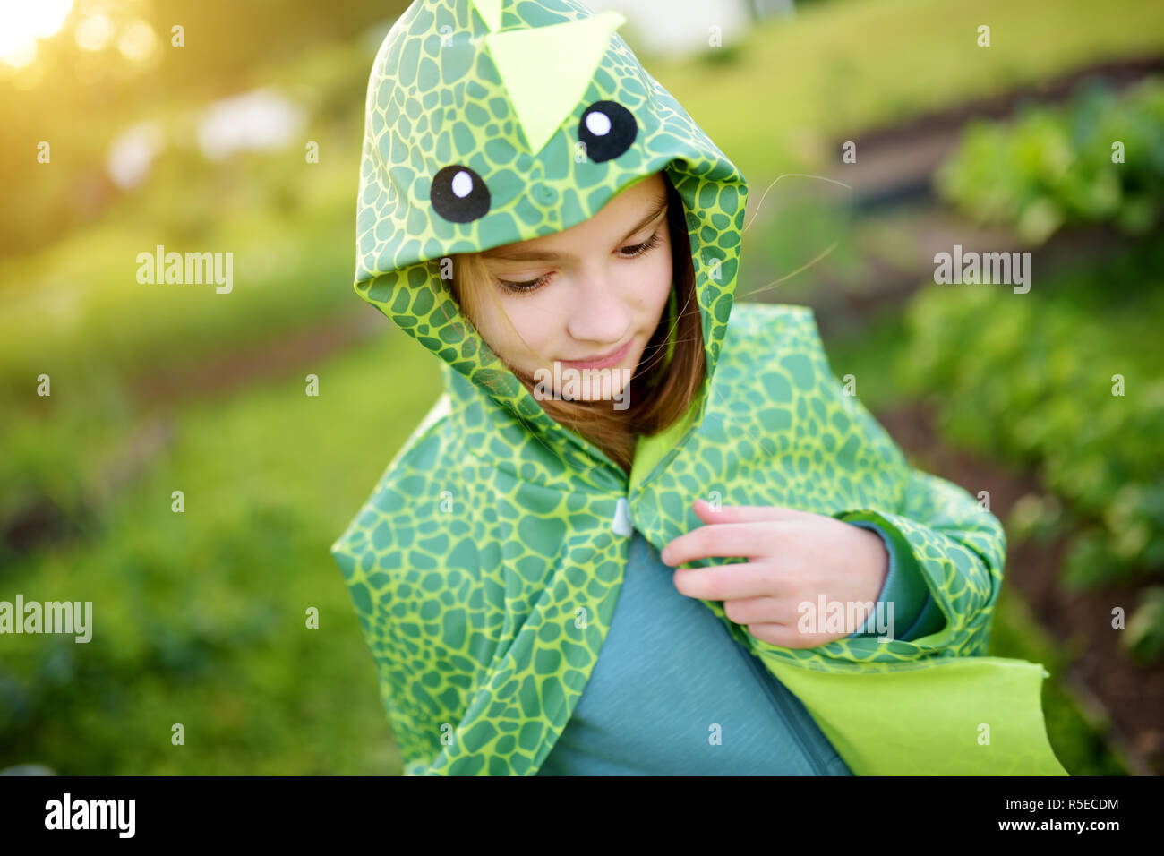 Funny little girl dressed as a dragon having fun outdoors on sunny ...