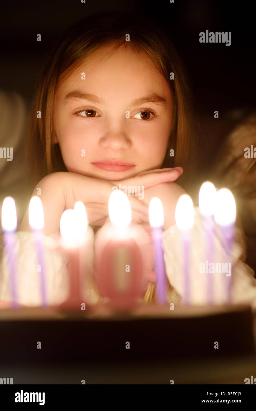 Cute Ten Years Old Girl Making A Wish Before Blowing Candles On Her