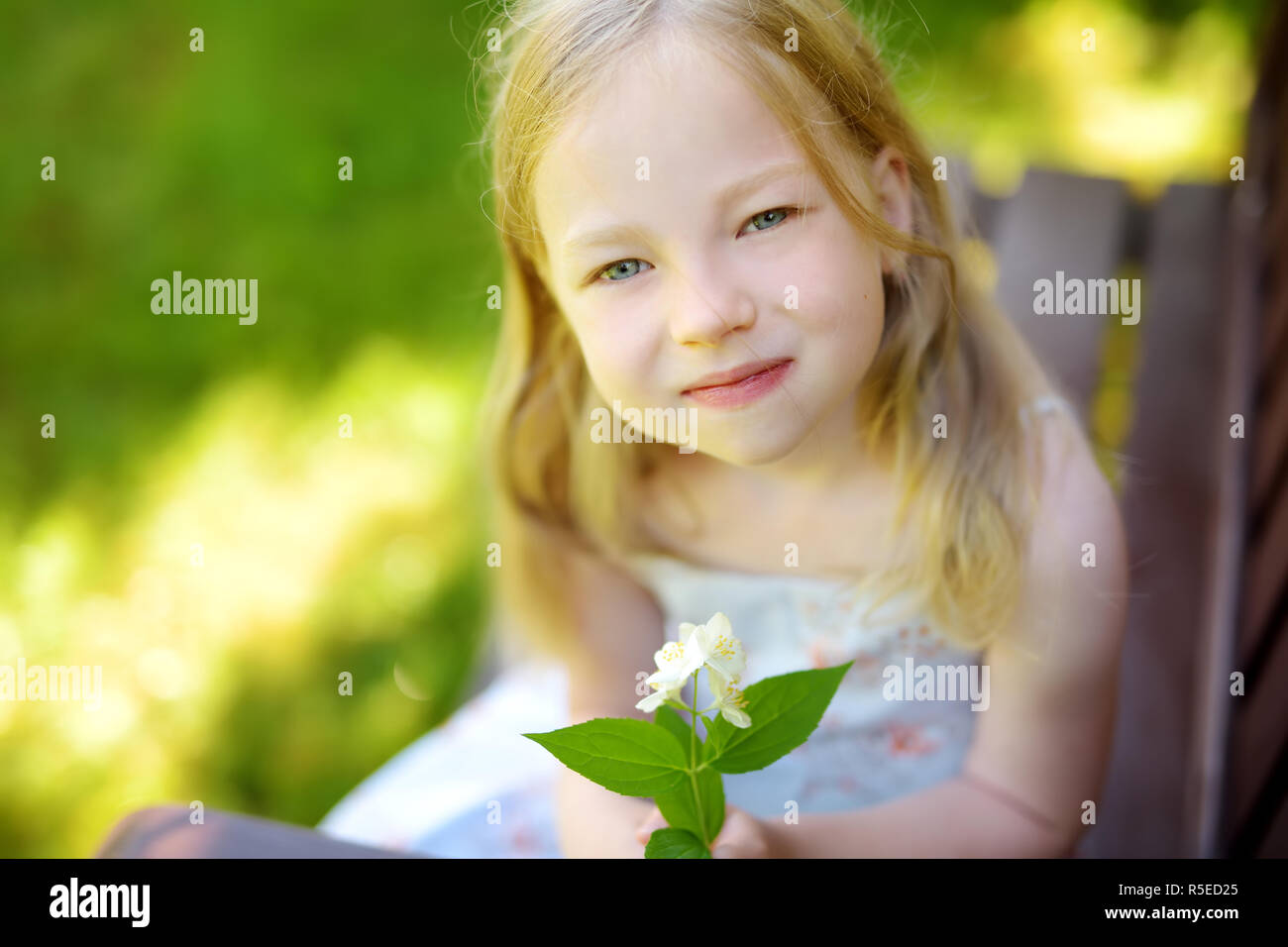 Cute little girl having fun on the backyard on sunny summer evening ...