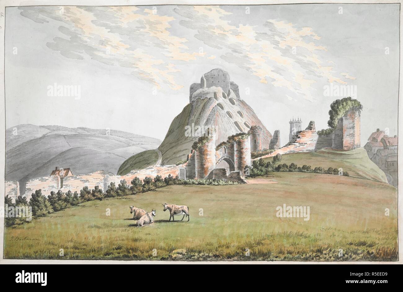 The ruins of Launceston Castle on a grassy hill; buildings on either ...