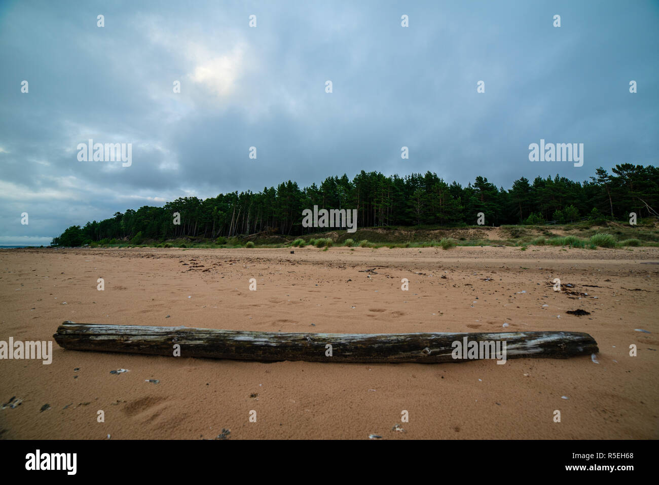 storm clouds forming over clear sea beach with rocks and clear sand ...