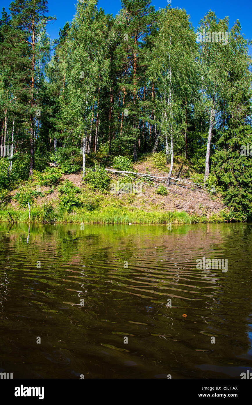 summer day on water in calm river enclosed in forests with sandstone ...
