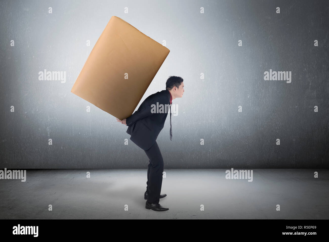 Asian business man carrying brown package on his back Stock Photo - Alamy