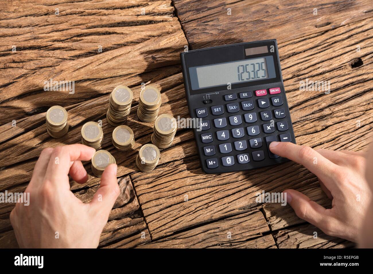 Man counting coins on calculator hi-res stock photography and images ...
