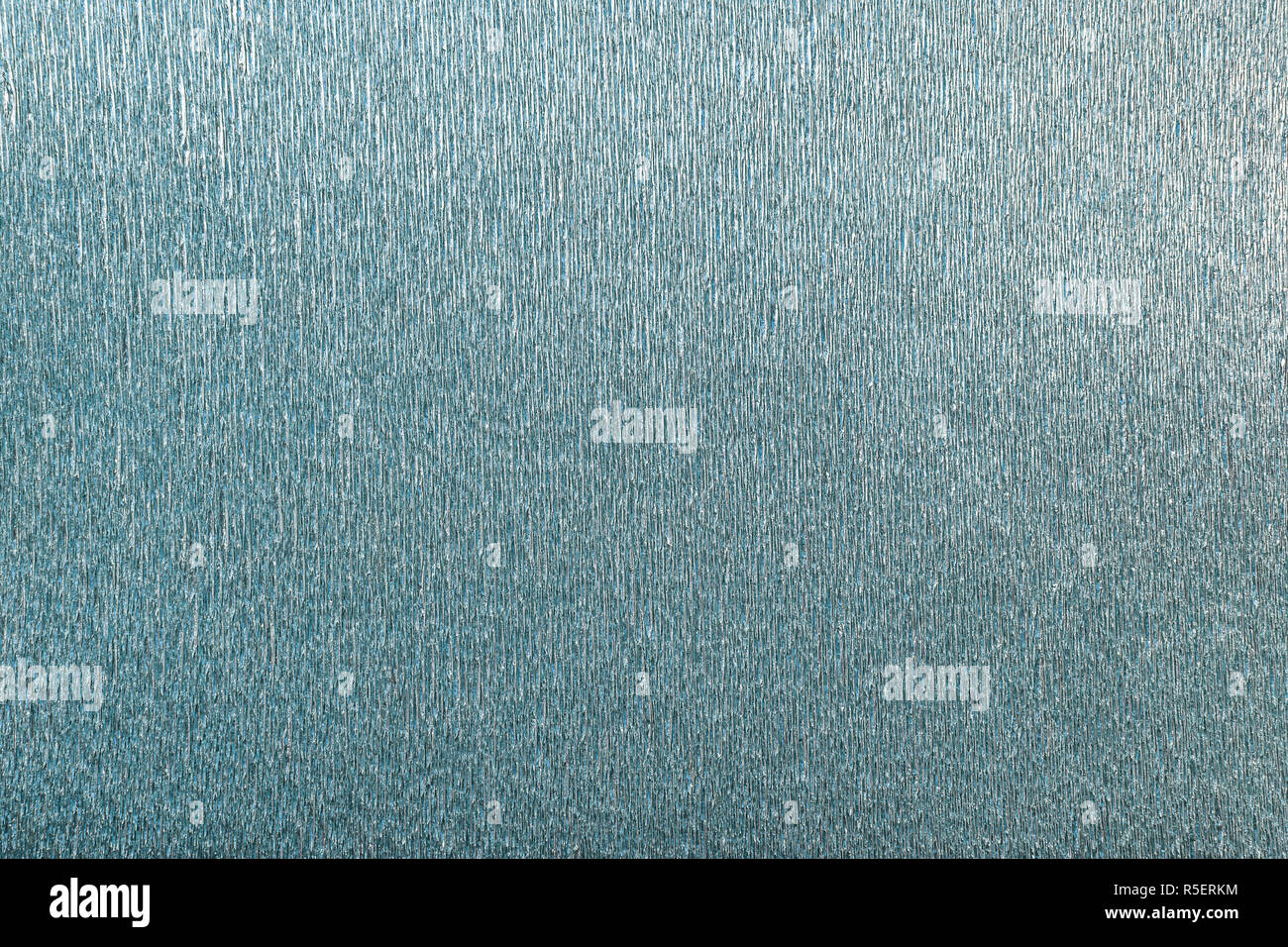 Textural of turquoise foil background of wavy corrugated paper, closeup ...
