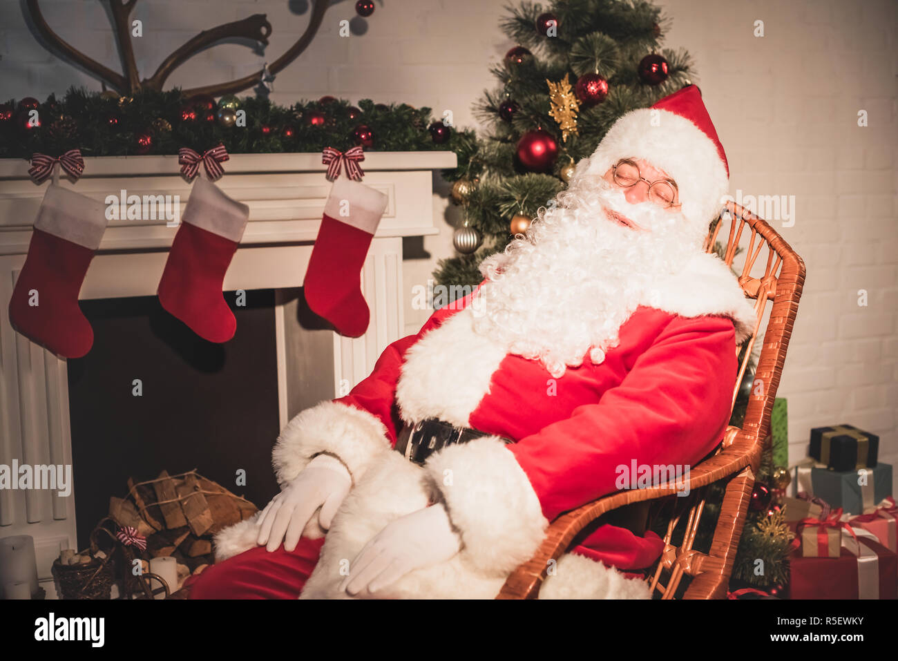 santa claus sleeping in rocking chair near fireplace with socks Stock ...