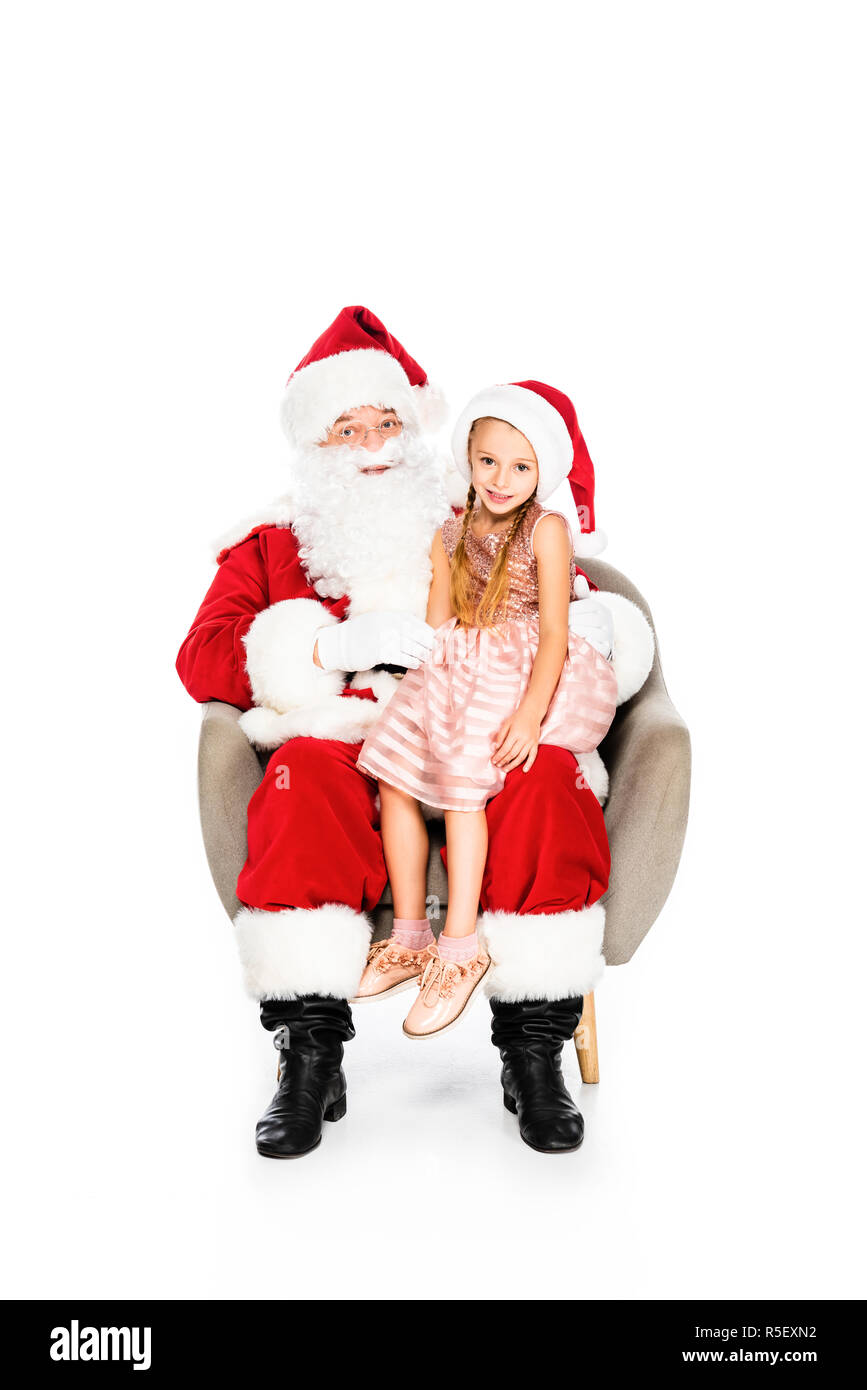 santa claus and little child sitting in armchair together and looking ...