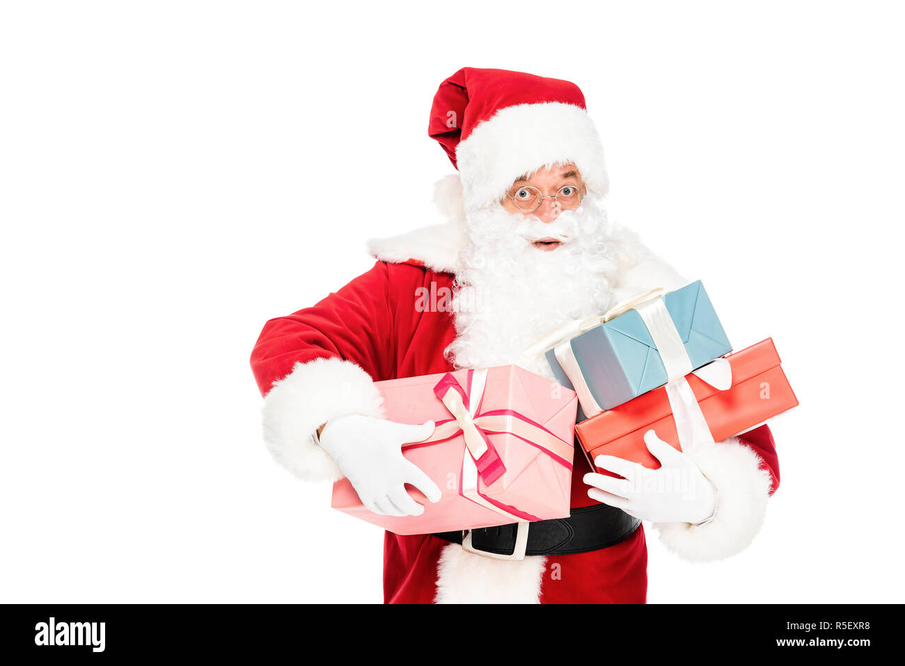santa claus holding pile of gift boxes and looking at camera with ...
