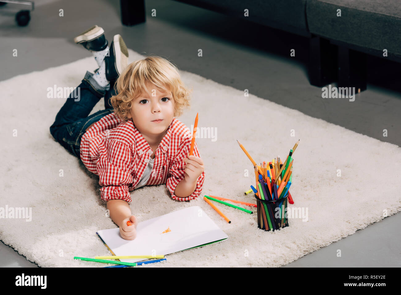 high angle view of adorable little boy drawing by marker at home Stock ...