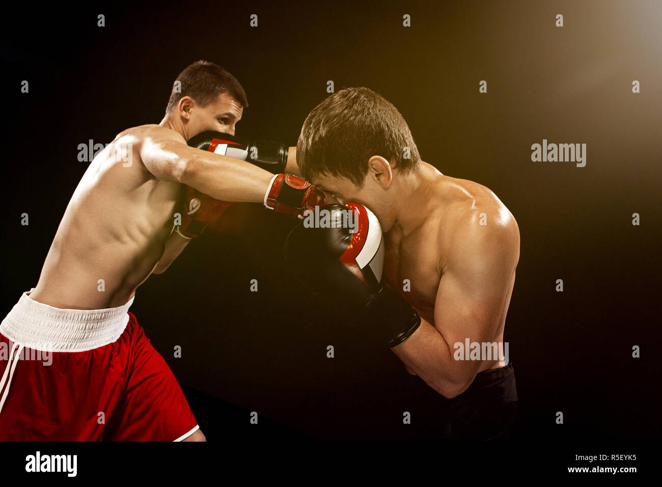 Two professional boxer boxing on black background Stock Photo - Alamy