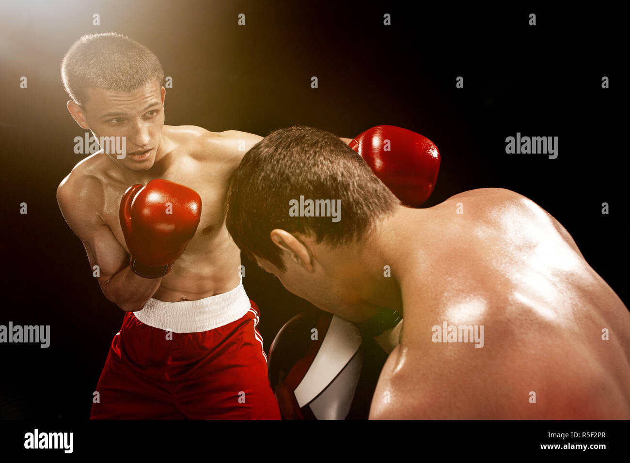 Two professional boxer boxing on black background Stock Photo - Alamy