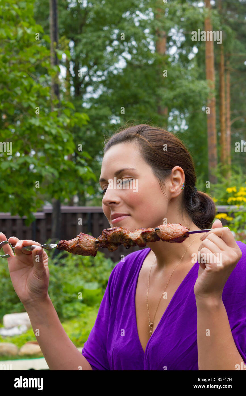pretty happy woman enjoying tasty barbecue bbq outdoors Stock Photo - Alamy