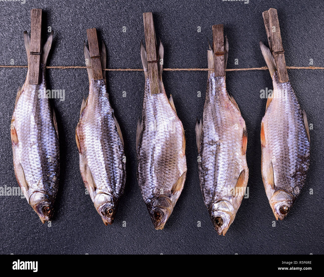 Dried fish hanging on a rope Stock Photo - Alamy