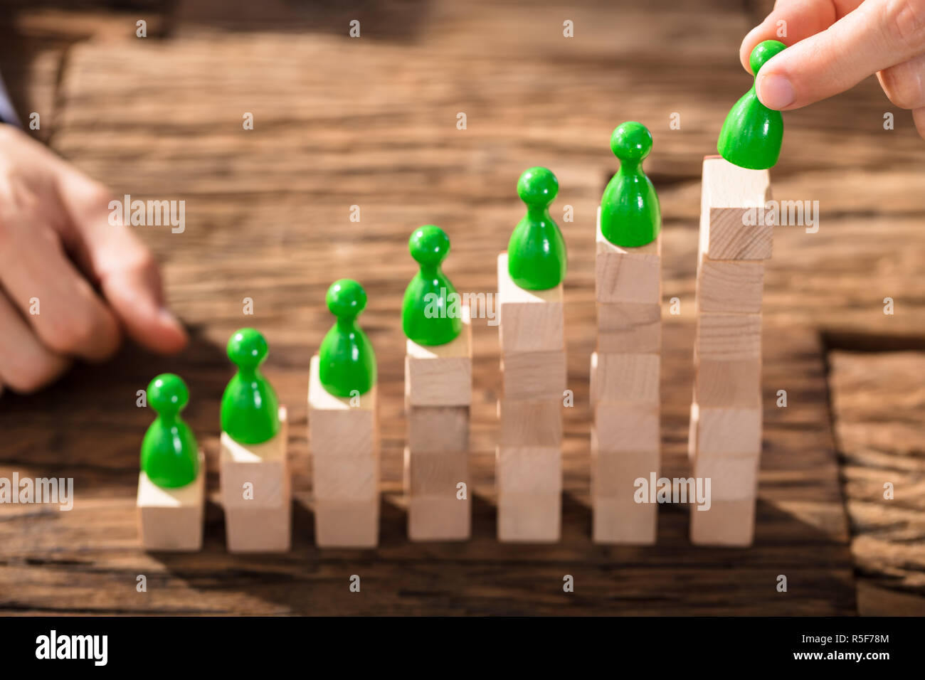 Businessman Arranging The Figures On Block Stack Stock Photo - Alamy
