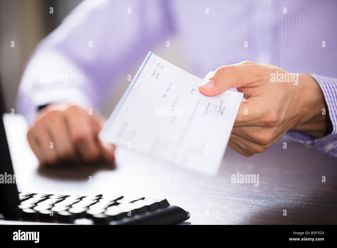 Businessperson's Hand Holding Cheque Stock Photo - Alamy
