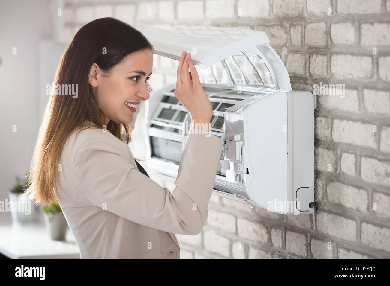Woman Opening Air Conditioner Stock Photo - Alamy