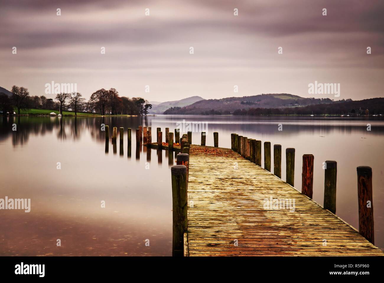A wooden boat jetty stretching out into Coniston Water in the Lake ...