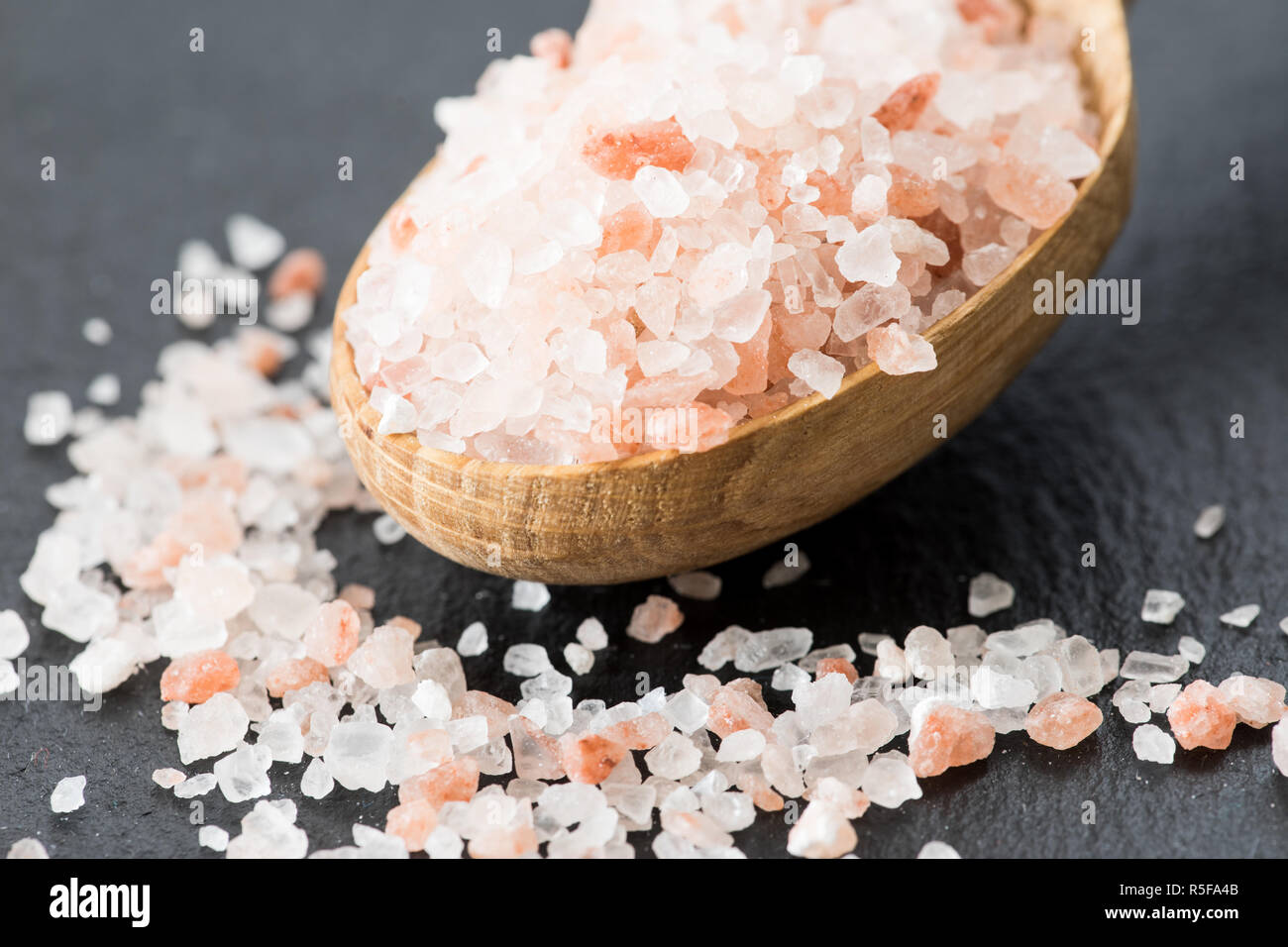 Himalayan pink crystal salt. spoon of pink himalayan salt on slate ...