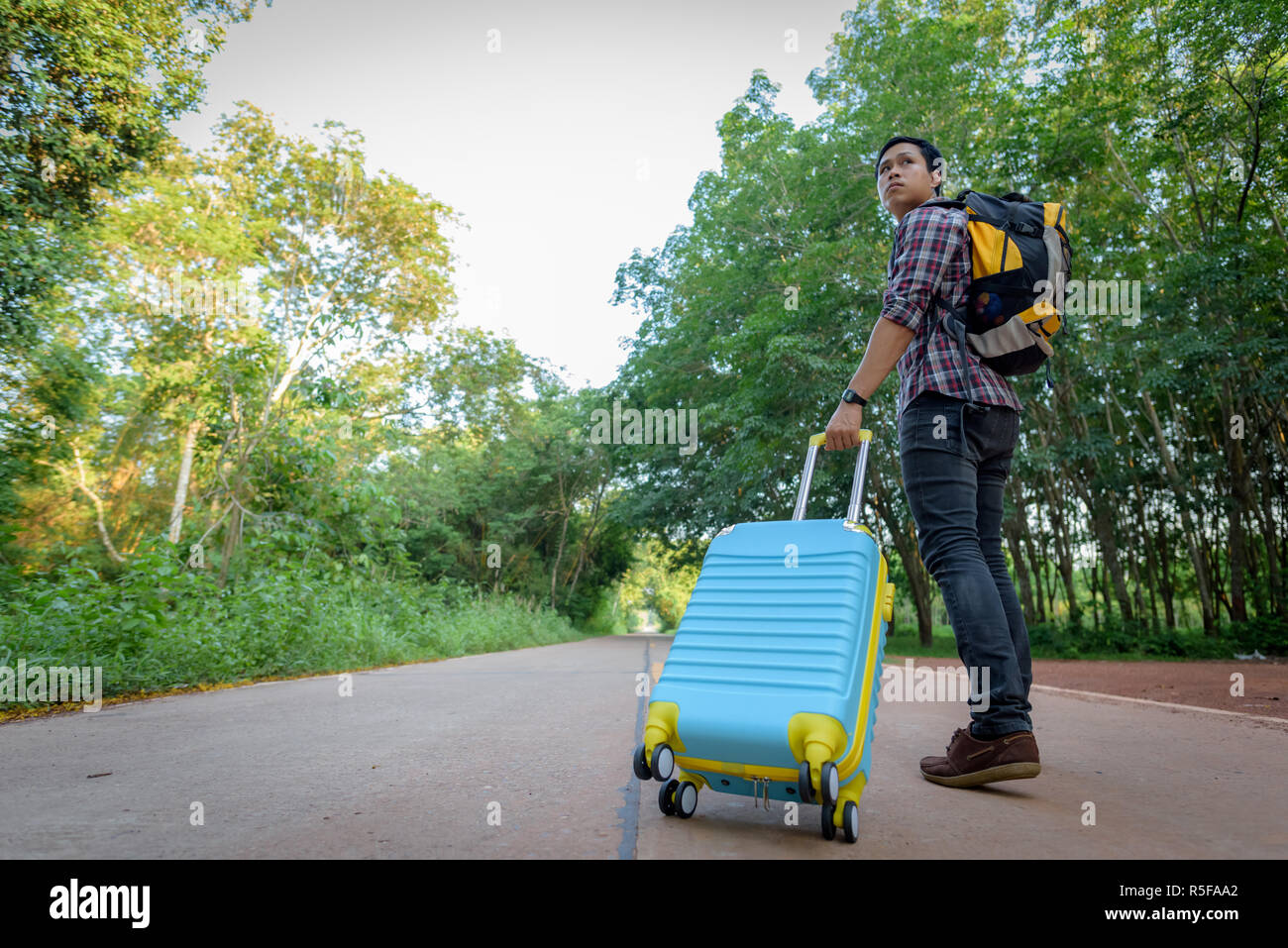 Backpacker is hitchhiking Stock Photo - Alamy