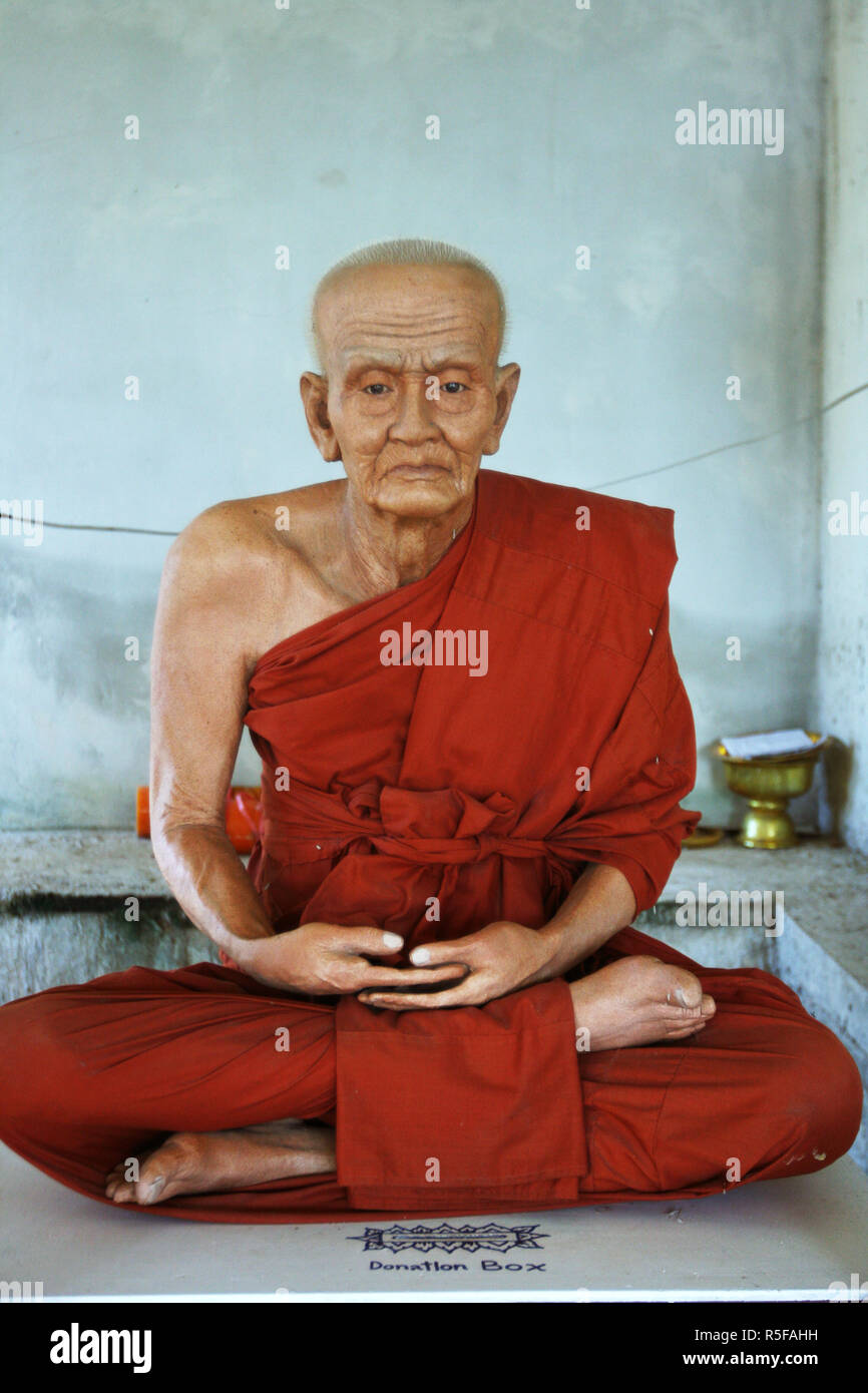 Praying monk sculpture in Thailand in temple Stock Photo - Alamy