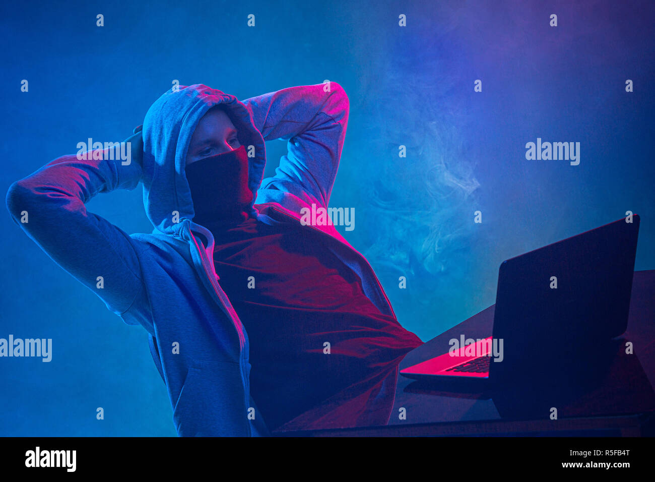 Hooded computer hacker stealing information with laptop Stock Photo - Alamy