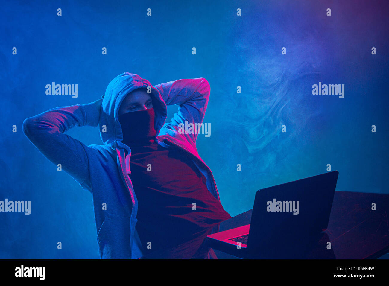 Hooded computer hacker stealing information with laptop Stock Photo - Alamy