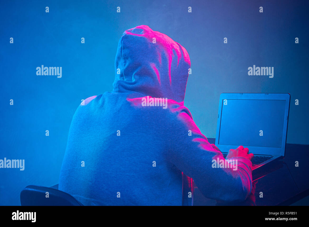 Hooded computer hacker stealing information with laptop Stock Photo - Alamy