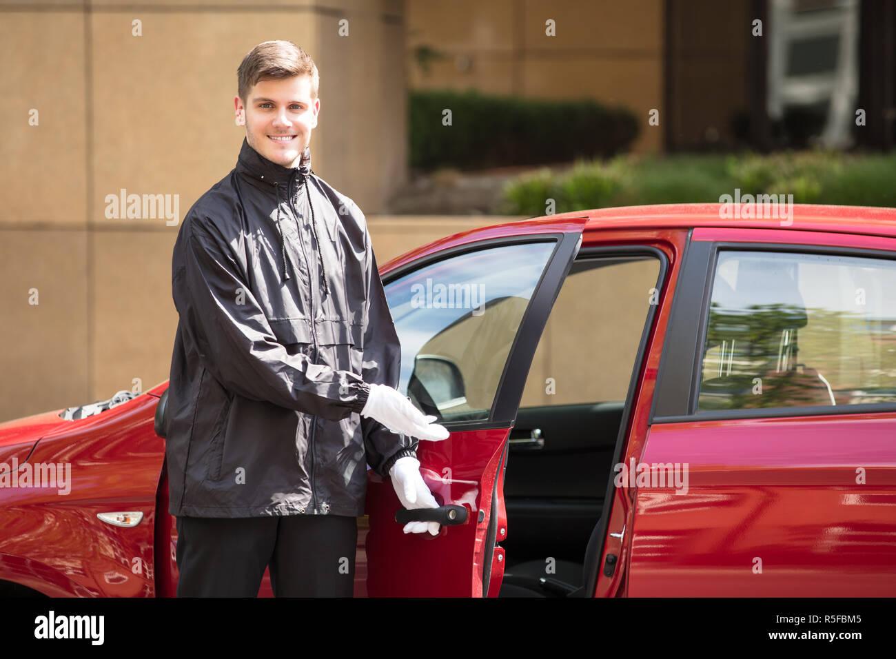 Happy Male Valet Opening Car Door Stock Photo - Alamy