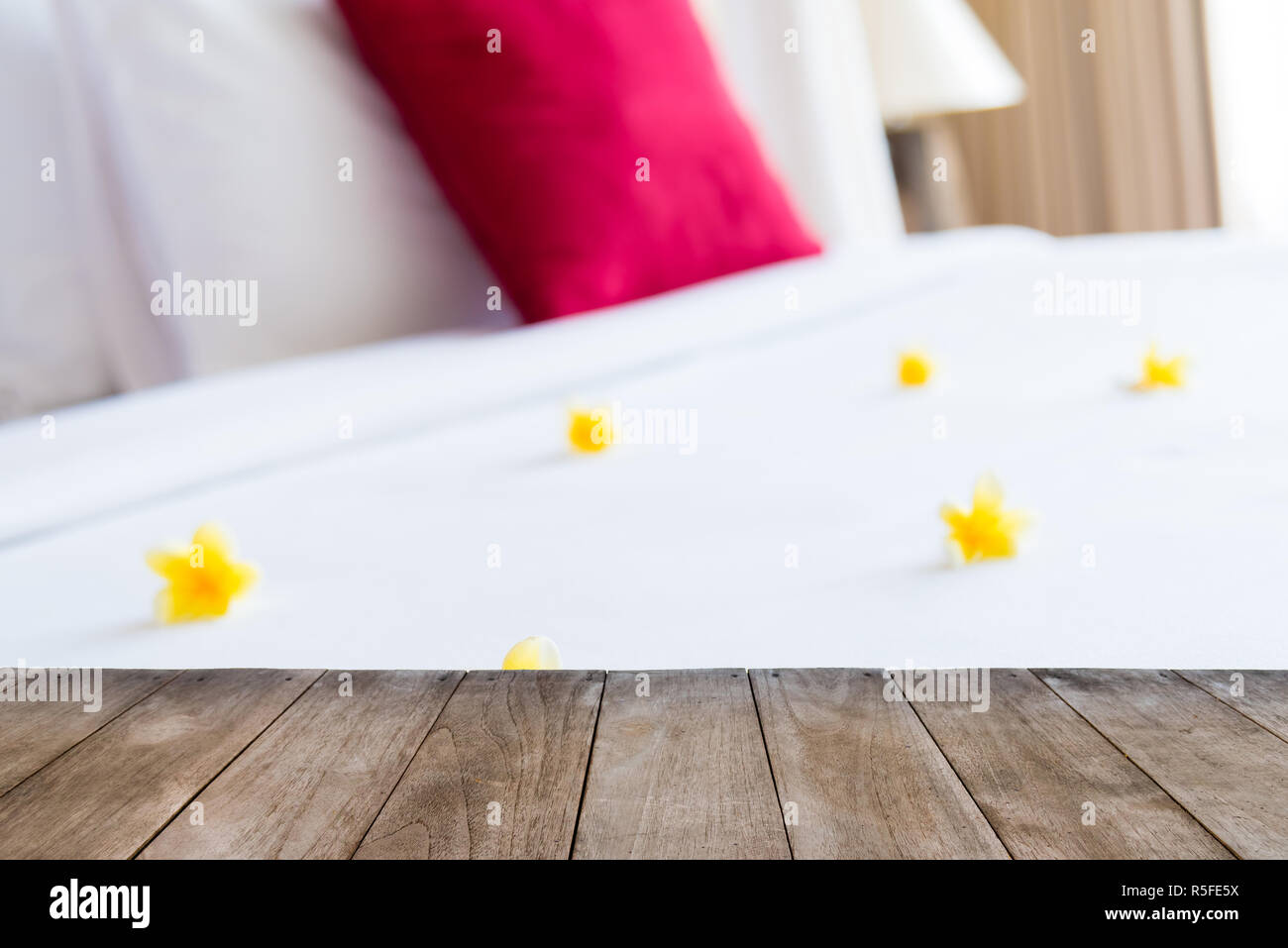 Perspective empty wooden table in front of hotel bed with flowers Stock ...