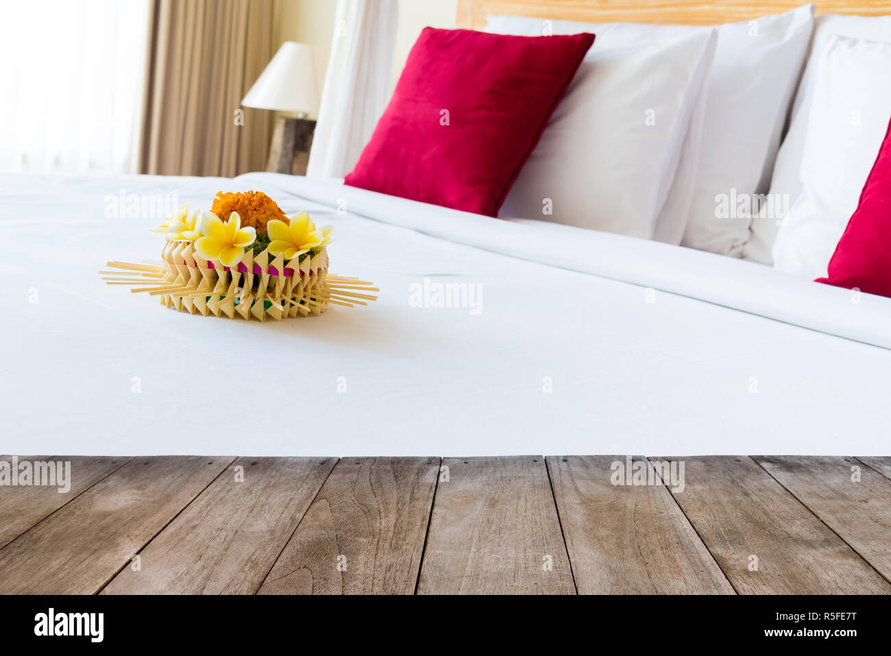 Perspective empty wooden table in front of hotel bed with flowers Stock ...