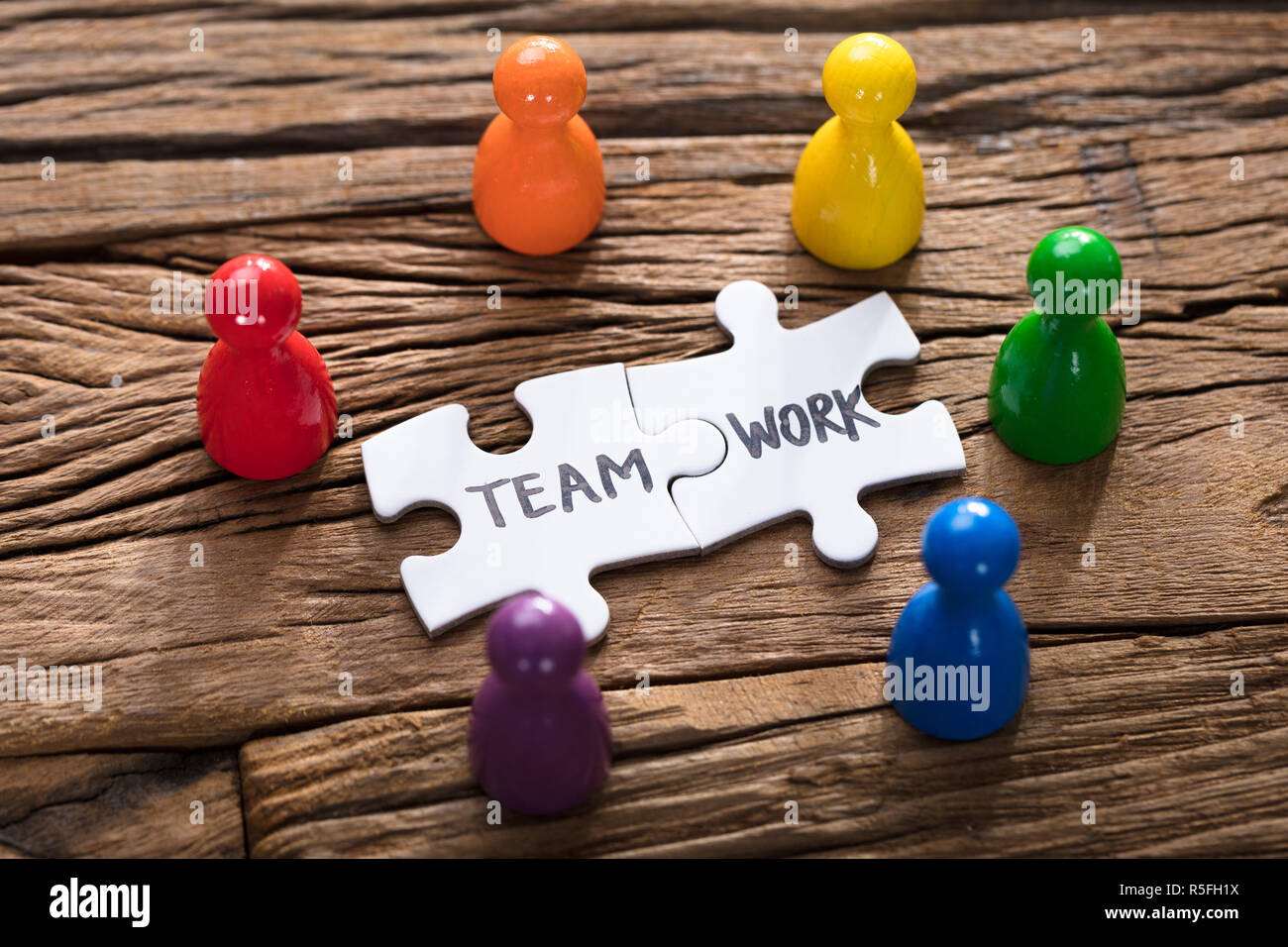 Teamwork Jigsaw Pieces Surrounded By Colorful Pawn Figurines Stock ...