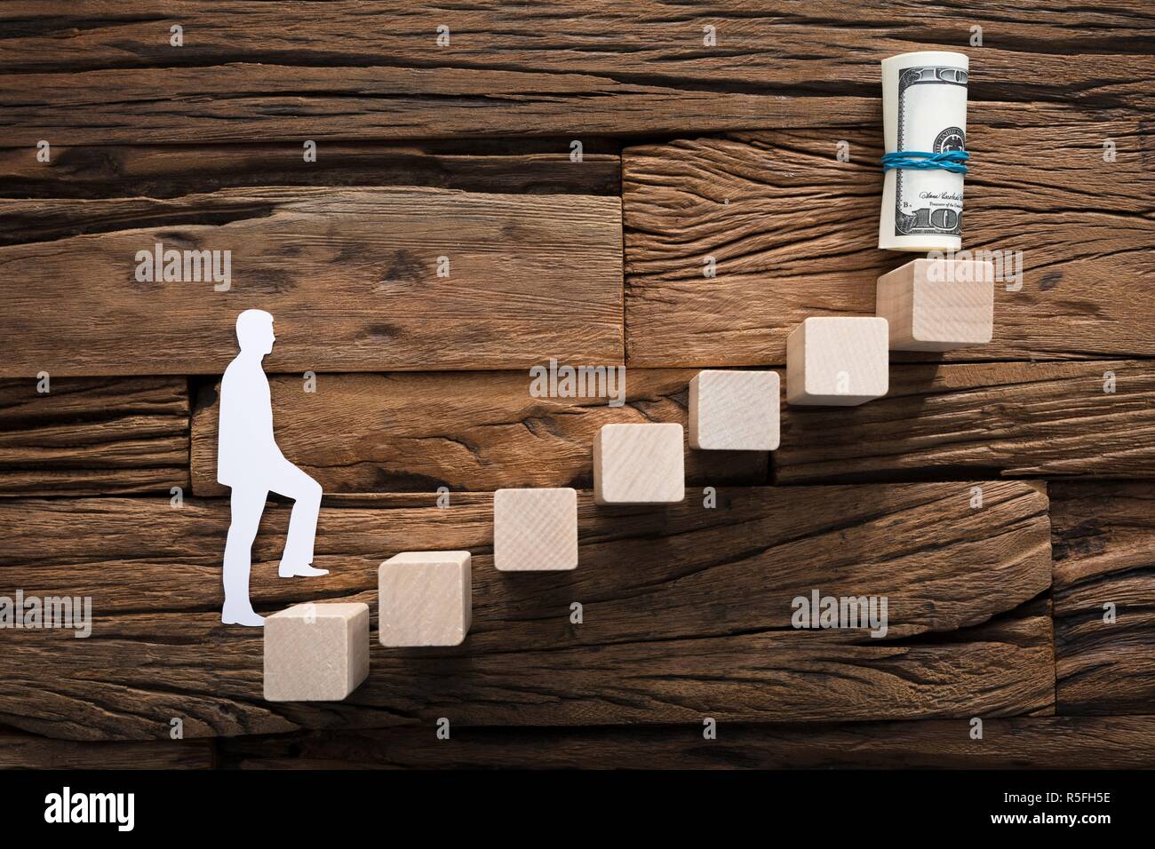 Paper Businessman Climbing Ladder Leading Towards Money Stock Photo - Alamy